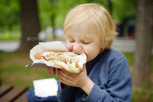 Child enjoying his to go meal outside. Fast food is a junk food ...
