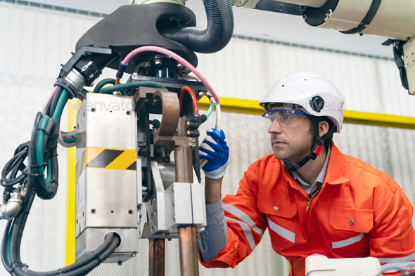 Engineer Man working at industrial robot in factory industrial. robotic ...