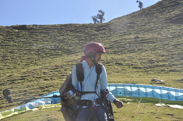 A Indian male tourist ready to paragliding flight with professional ...