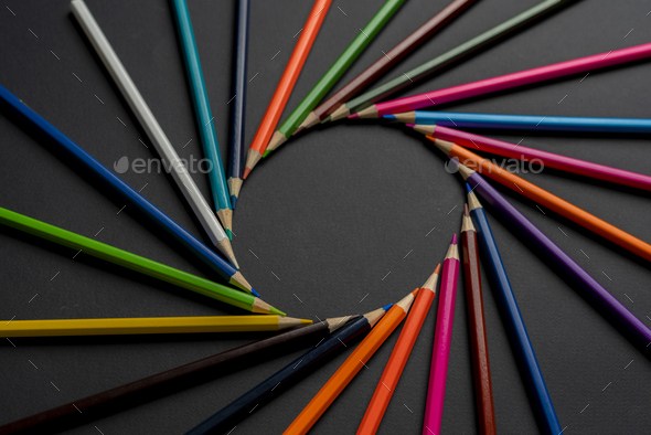 a creative idea of colorful crayons making a circle shape on the pastel ...