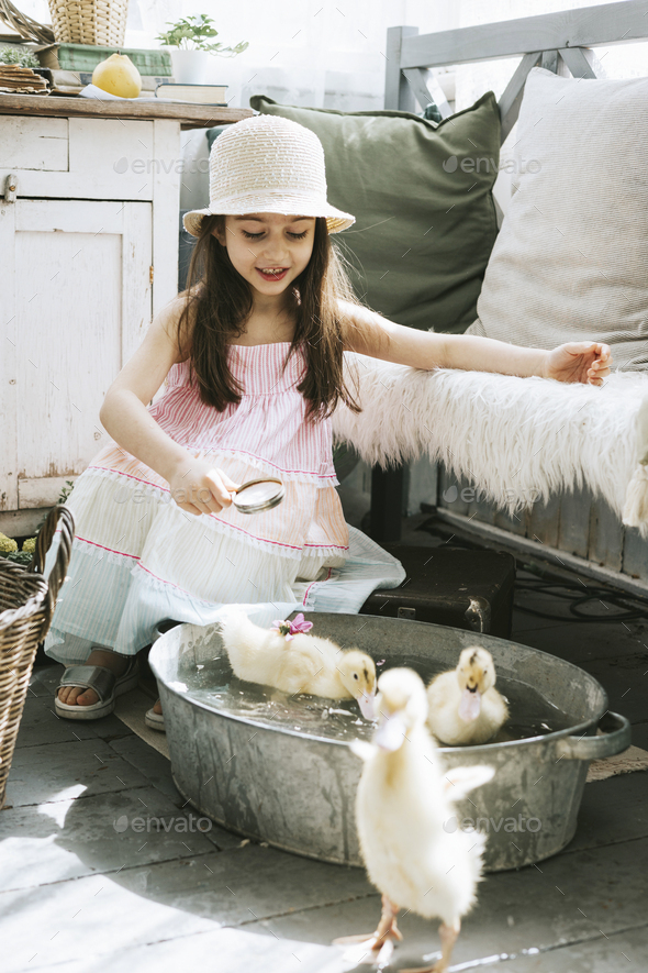 pretty little Armenian girl sit on veranda on sunny spring day ...