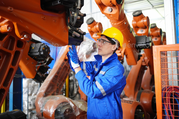 Engineer Man working at industrial robot in factory industrial. robotic ...