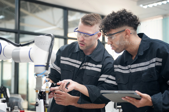 Robotics control engineers setting programming of control panel for ...