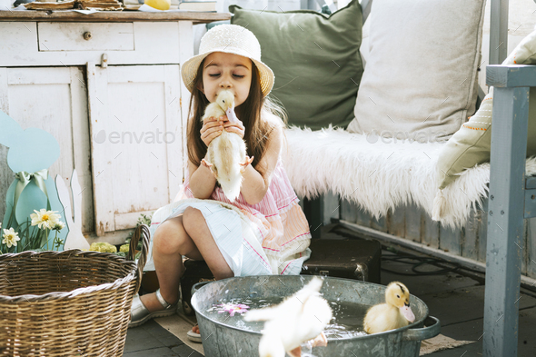 pretty little Armenian girl sit on veranda on sunny spring day ...