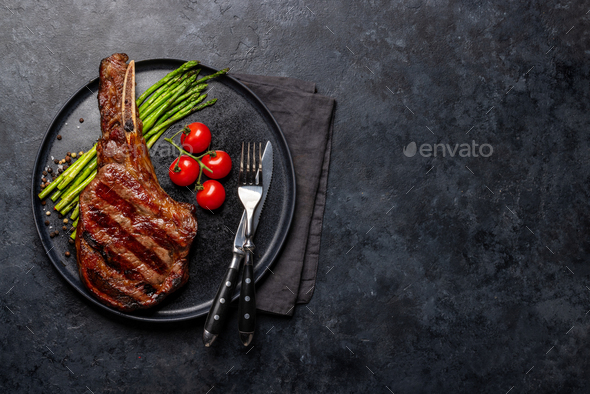 Medium rare grilled Tomahawk beef steak with asparagus Stock Photo by ...
