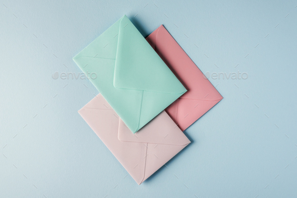 Collection of envelopes in pastel colors on a light blue background ...