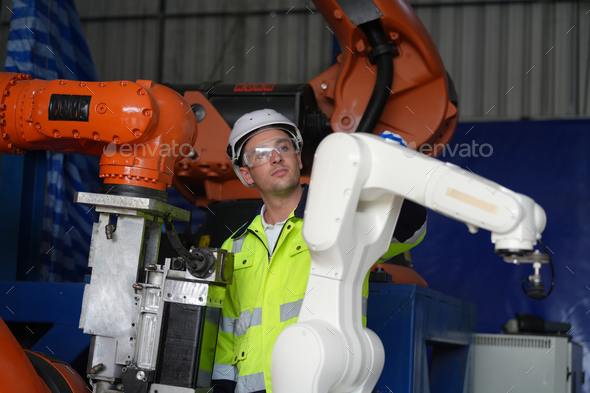 Engineer Man working at industrial robot in factory industrial. Stock ...