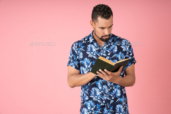 Serious and surprised man reading a book Stock Photo by GSR-PhotoStudio
