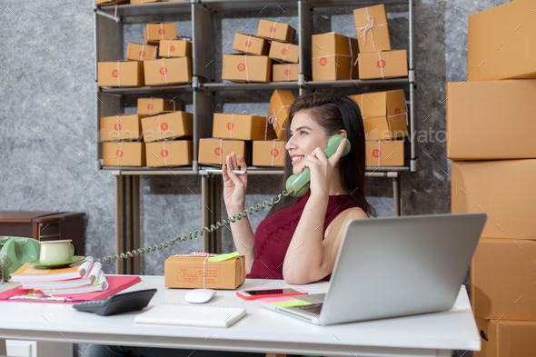 Online business owner. Asian woman in a casual workday packing products ...