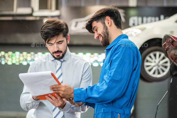 Car mechanic explaining repair checklist to customer Stock Photo by ...