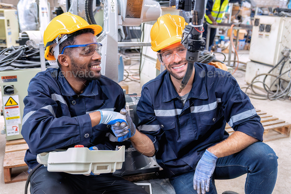 Maintenance engineer repair and programing robotic arm in factory ...