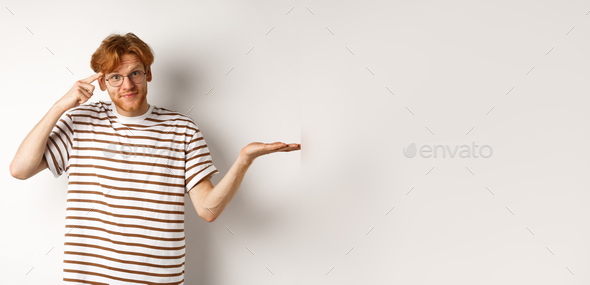 Are you stupid. Confused redhead guy in glasses shrugging, pointing at ...