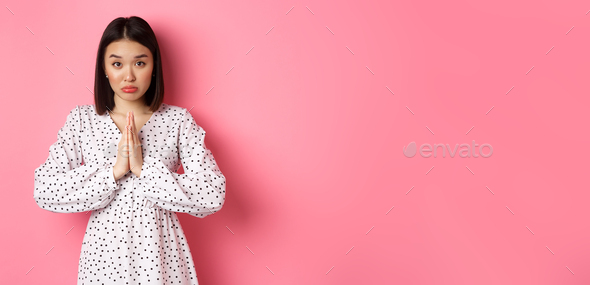 Cute asian girl asking for help, begging for favour and looking ...