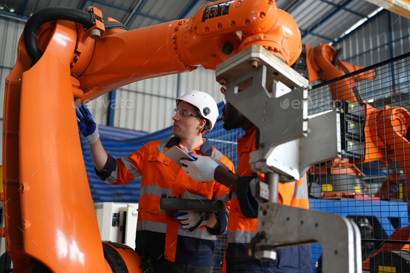 Engineer Man working at industrial robot in factory industrial. robotic ...