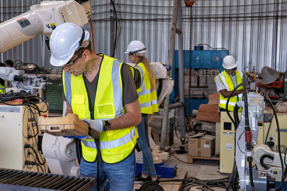 In robotic maintenance shop engineer busy commissioning and operate ...