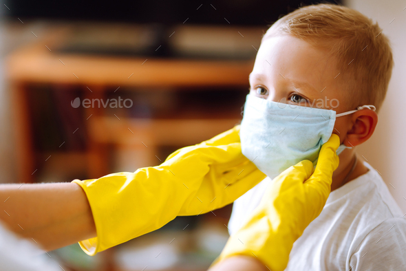 Little boy and mom in medical mask. Mother puts on her baby sterile ...
