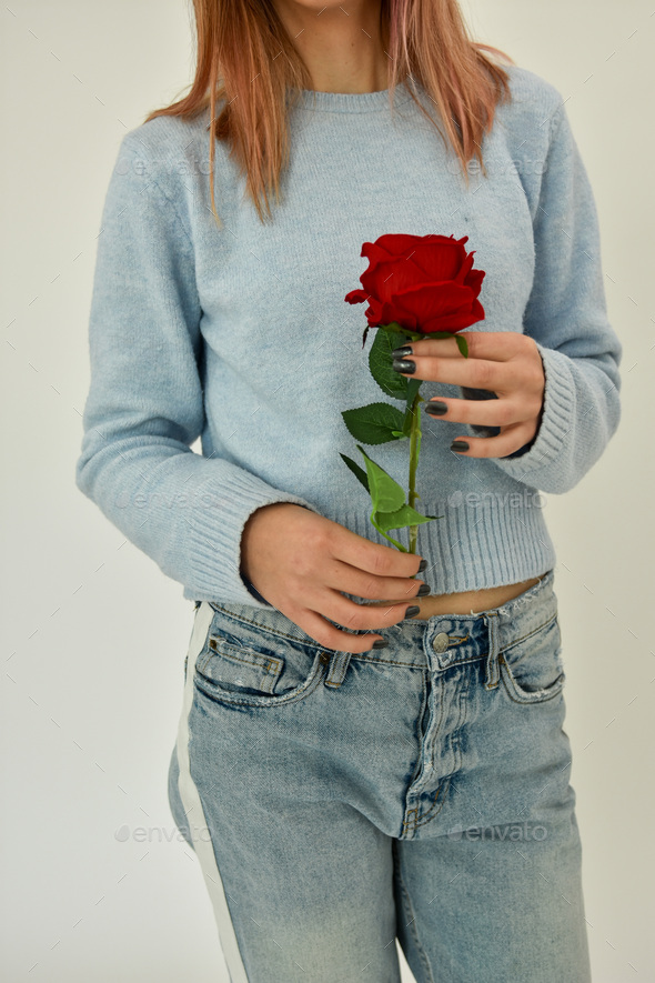 Young girl holding a red rose in her hand. Gift for Valentine's day ...