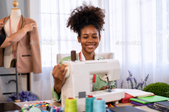 Stylish fashionable clothes designer girl at a sewing machine design ...