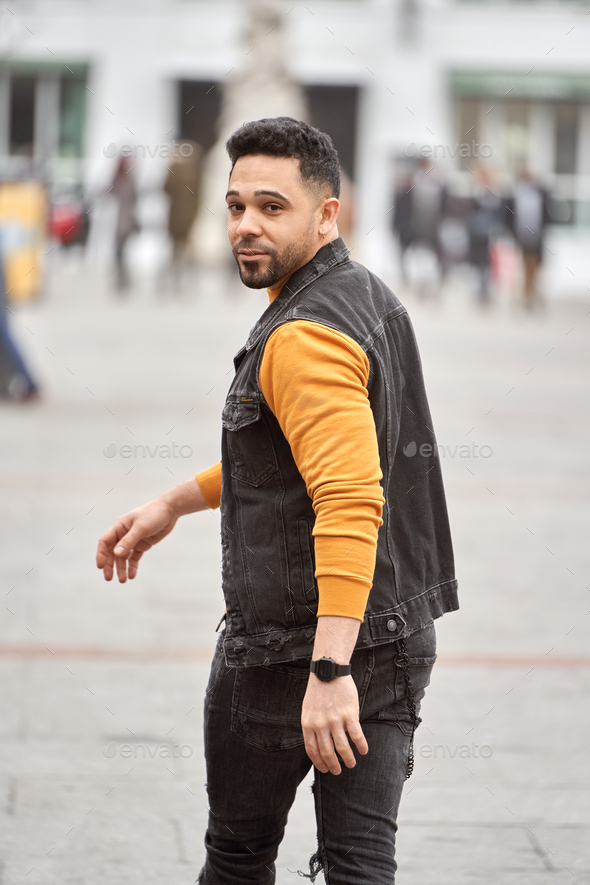 Man looking back while walking outdoors on the street. Stock Photo by ...