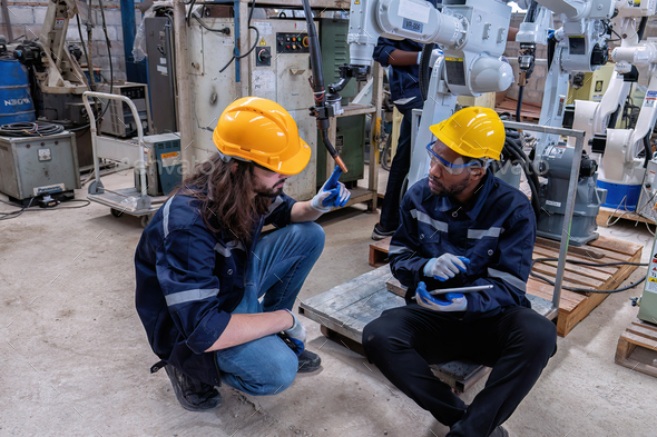 Maintenance engineer repair and programing robotic arm in factory ...