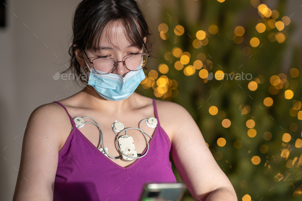 Girl wears a Holter with electrodes on her chest for continuous ...