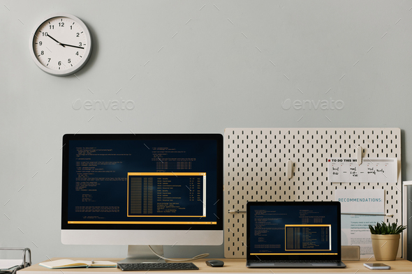 Office workplace setup with computer code on two screens Stock Photo by ...
