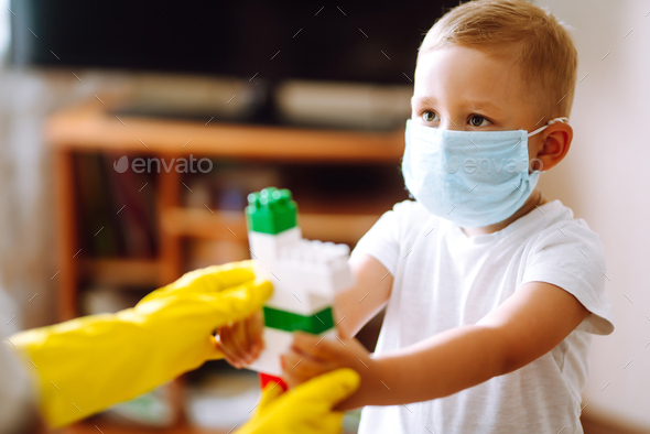 Little boy and mom in medical mask. Mother puts on her baby sterile ...