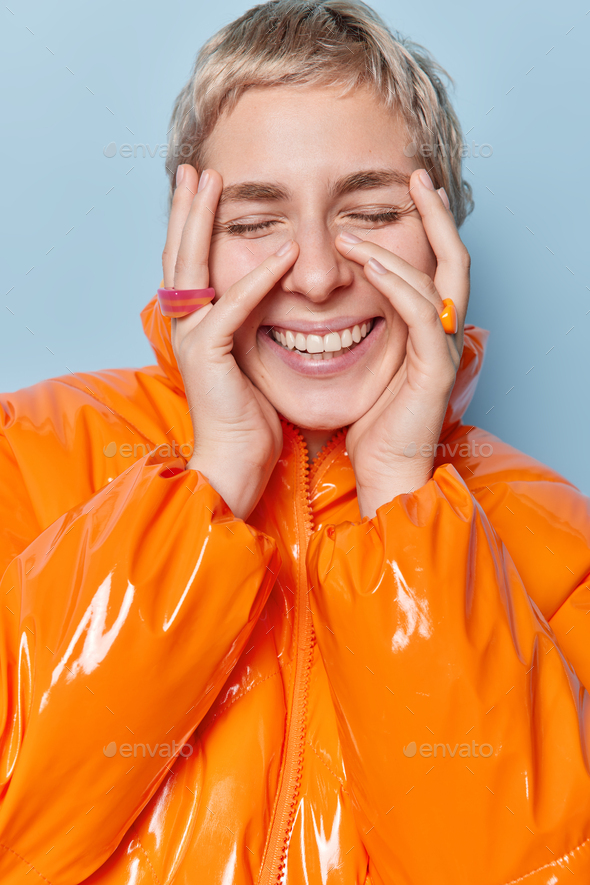 Vertical image of positive short haired woman keeps eyes closed touches ...