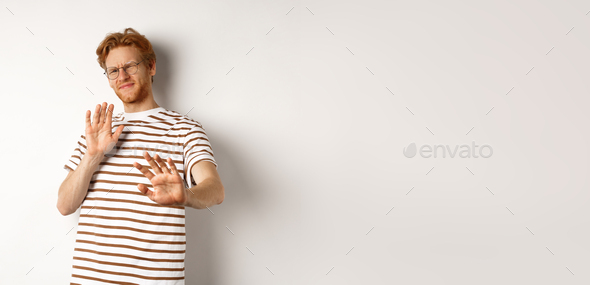 Displeased young man with red hair and bristle showing stop gesture ...