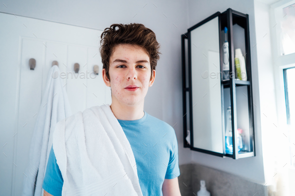 Portrait of smiling handsome teenage boy with acne problem who takes ...