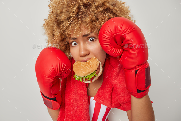 Scared worried female boxer wears boxing gloves tries to protect ...