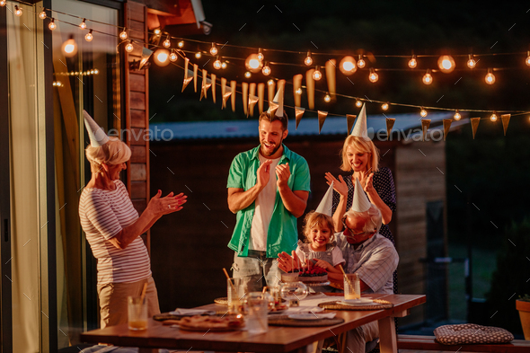 Family singing birthday song and celebrating Stock Photo by bernardbodo