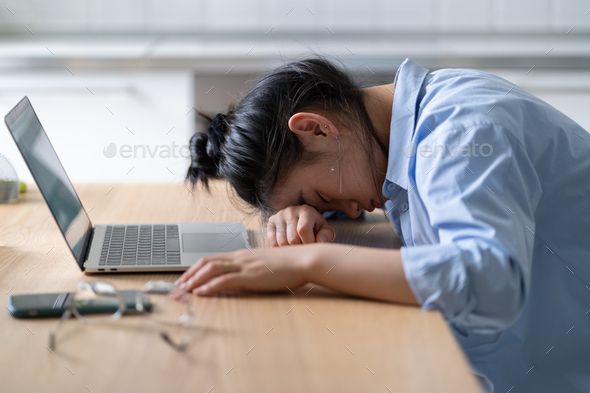Work burnout. Tired asian woman putting head down on table, suffering ...