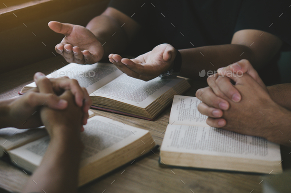 Group of christian people reading and study bible in home and pray ...
