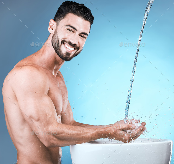 Water splash, portrait and man cleaning hands in studio isolated on a ...