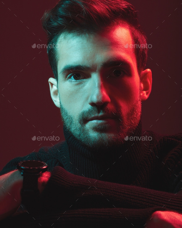 Portrait, serious and red with a handsome man model in studio on a dark ...