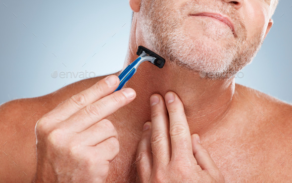Grooming, razor and man shaving his beard in a studio for a facial ...