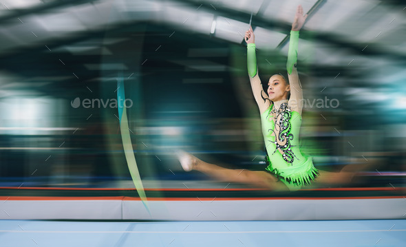 Gymnastics, fitness and woman with jump and motion blur, sport in gym ...