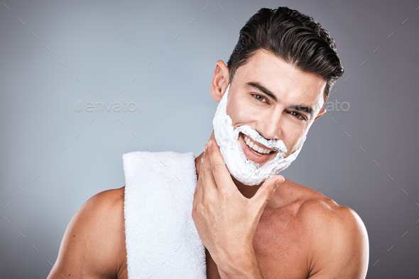Portrait, shaving cream and grooming with a man model in studio on a gray background for hair ...