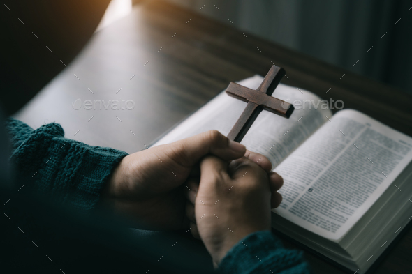 Close up of an open bible with a cross for morning devotion on a wooden ...