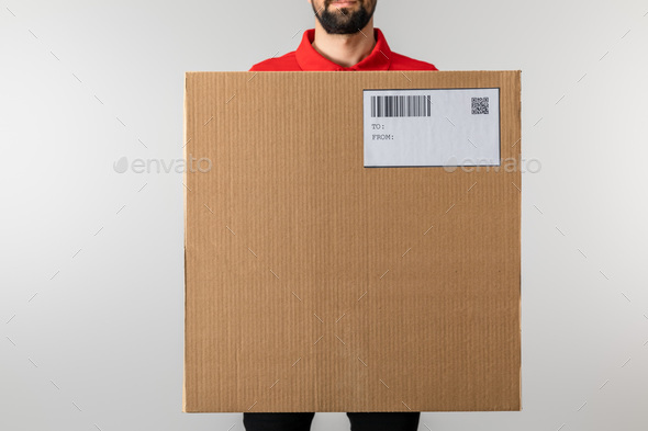 Cropped view of courier holding package with barcode and qr code on ...