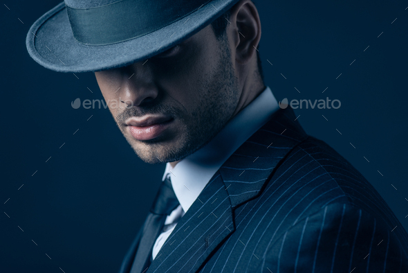 Portrait of mafioso in felt hat on dark blue background Stock Photo by ...