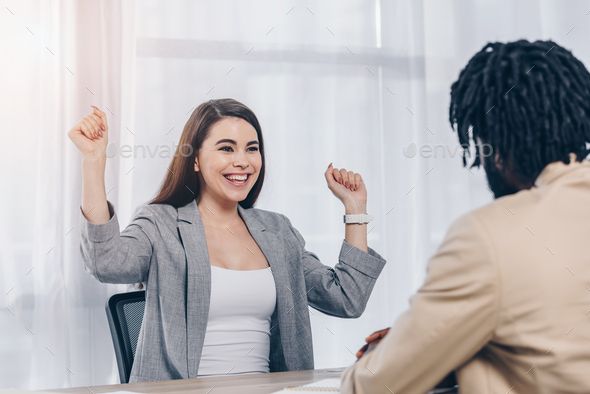 Selective focus of happy and excited employee with african american ...