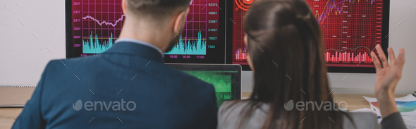 Back view of data analysts working on strategy of security with graphs on computer monitors ...