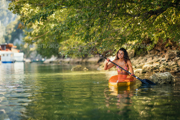 Female in bikini kayaking on lake during sunny day Stock Photo by ...