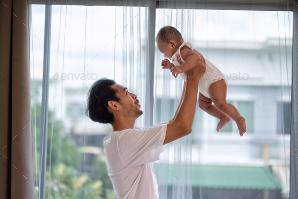 Father happy joyful hold asian infant baby new born fly like airplane ...