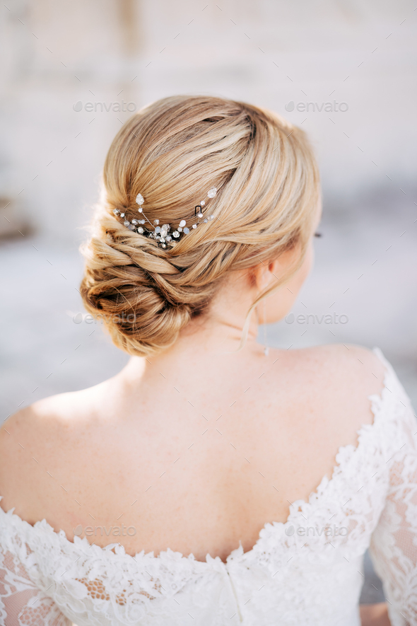 Blonde bride with a beautiful hairstyle and in a dress with bare ...