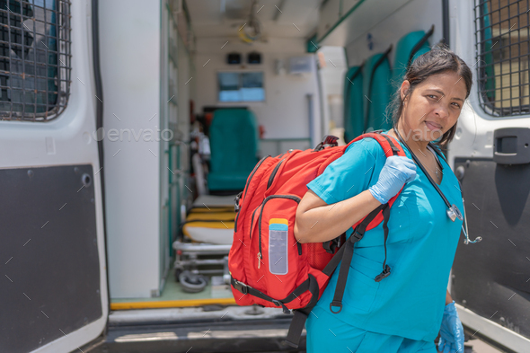 Medical technician with a first aid bag standing next to an ambulance ...