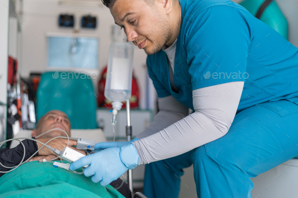 Doctor checking a patient's pulse in an ambulance Stock Photo by GSR ...