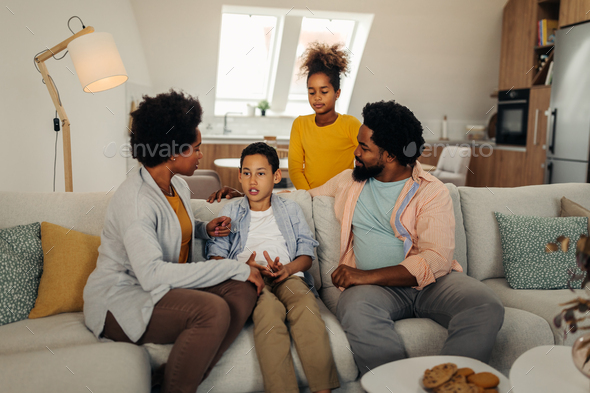 Afro parents and their children are socializing while sitting on the ...